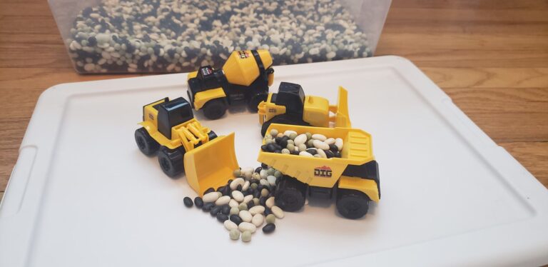 Construction Themed Sensory Bin with Mini Dump Trucks
