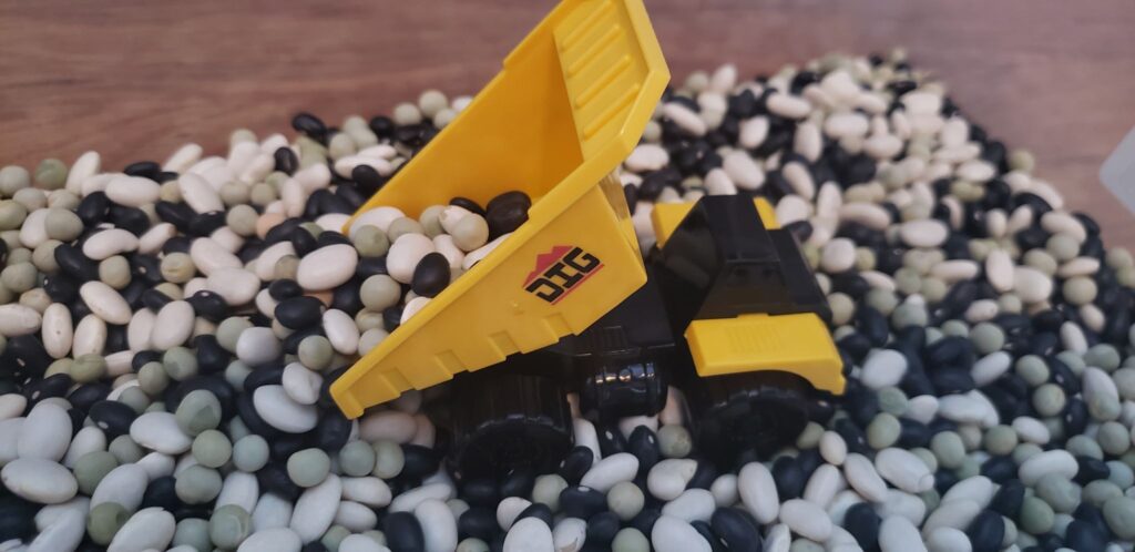 Construction Themed Sensory Bin with Mini Dump Trucks